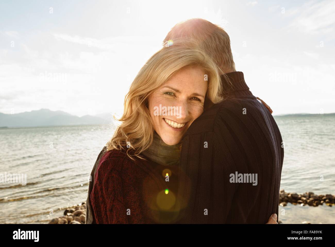 Mature couple beside lake, hugging, smiling Stock Photo - Alamy
