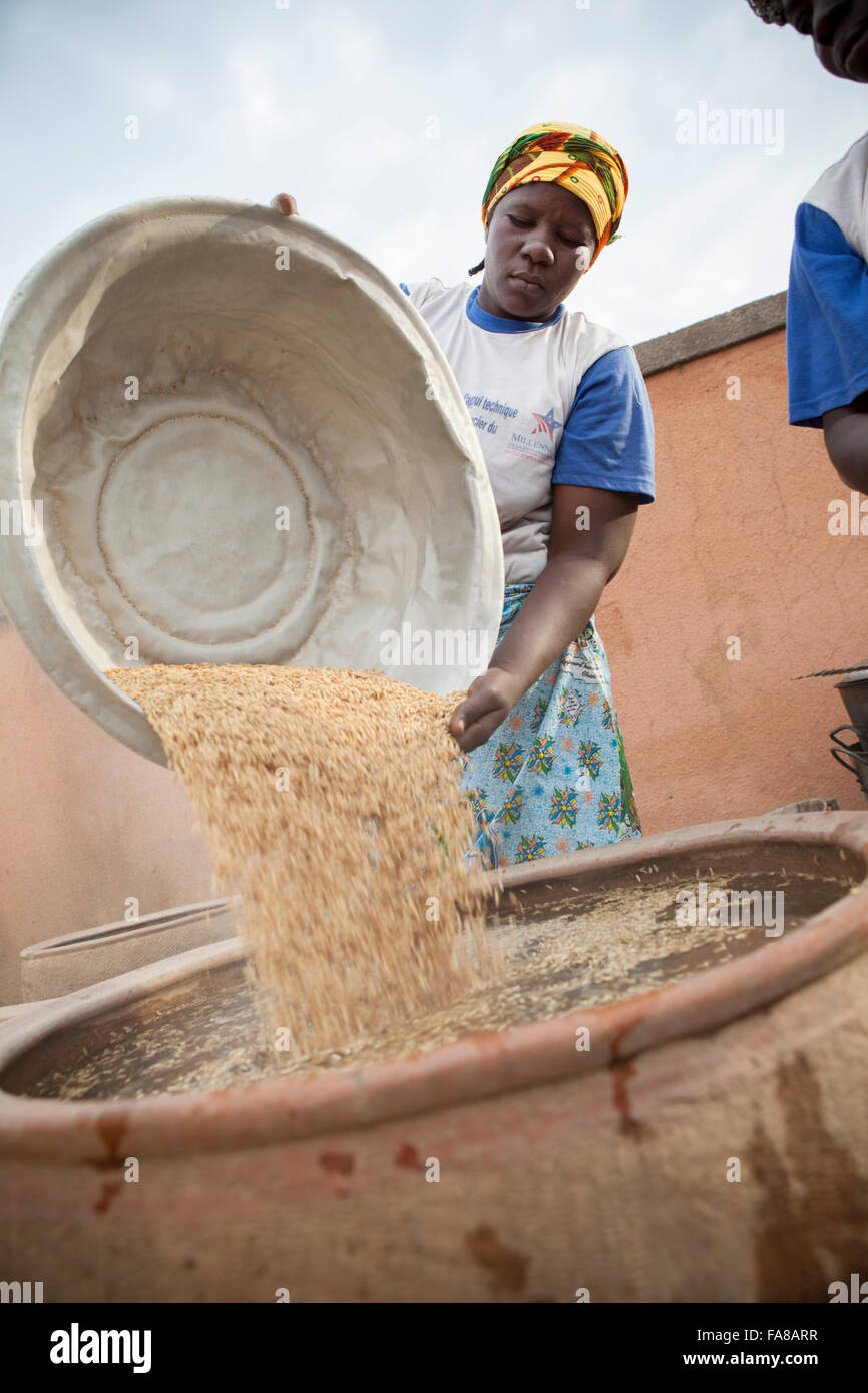 Rice is parboiled before being sold at a women's group processing ...