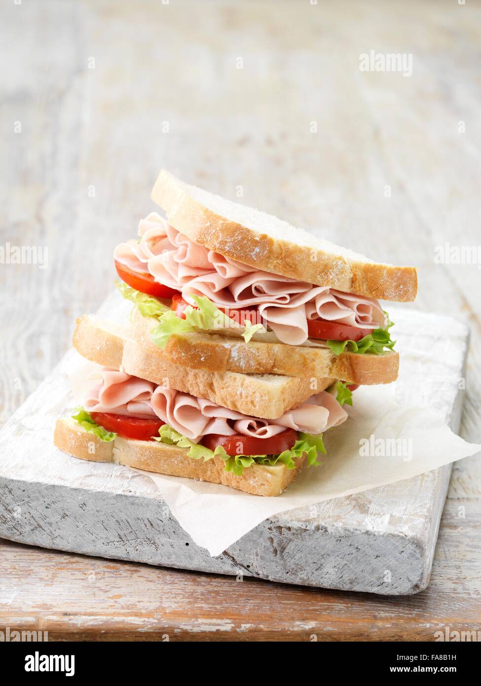 Stack of wafer thin ham sandwiches on sliced white bread with salad ...