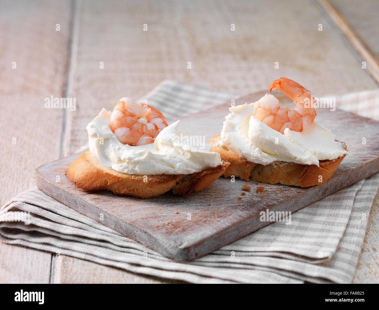 Soft cheese and cooked prawns on sliced crusty baguette Stock Photo - Alamy