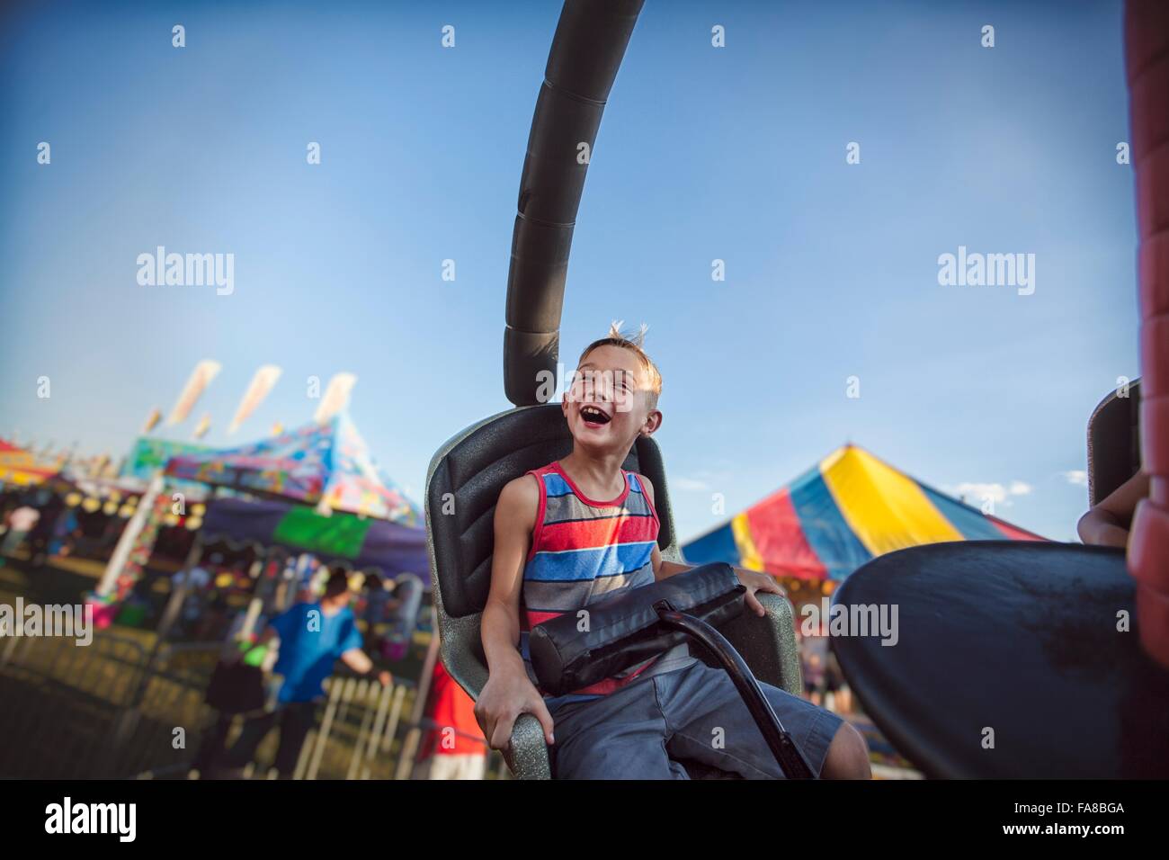 Young boy enjoying fairground ride Stock Photo - Alamy