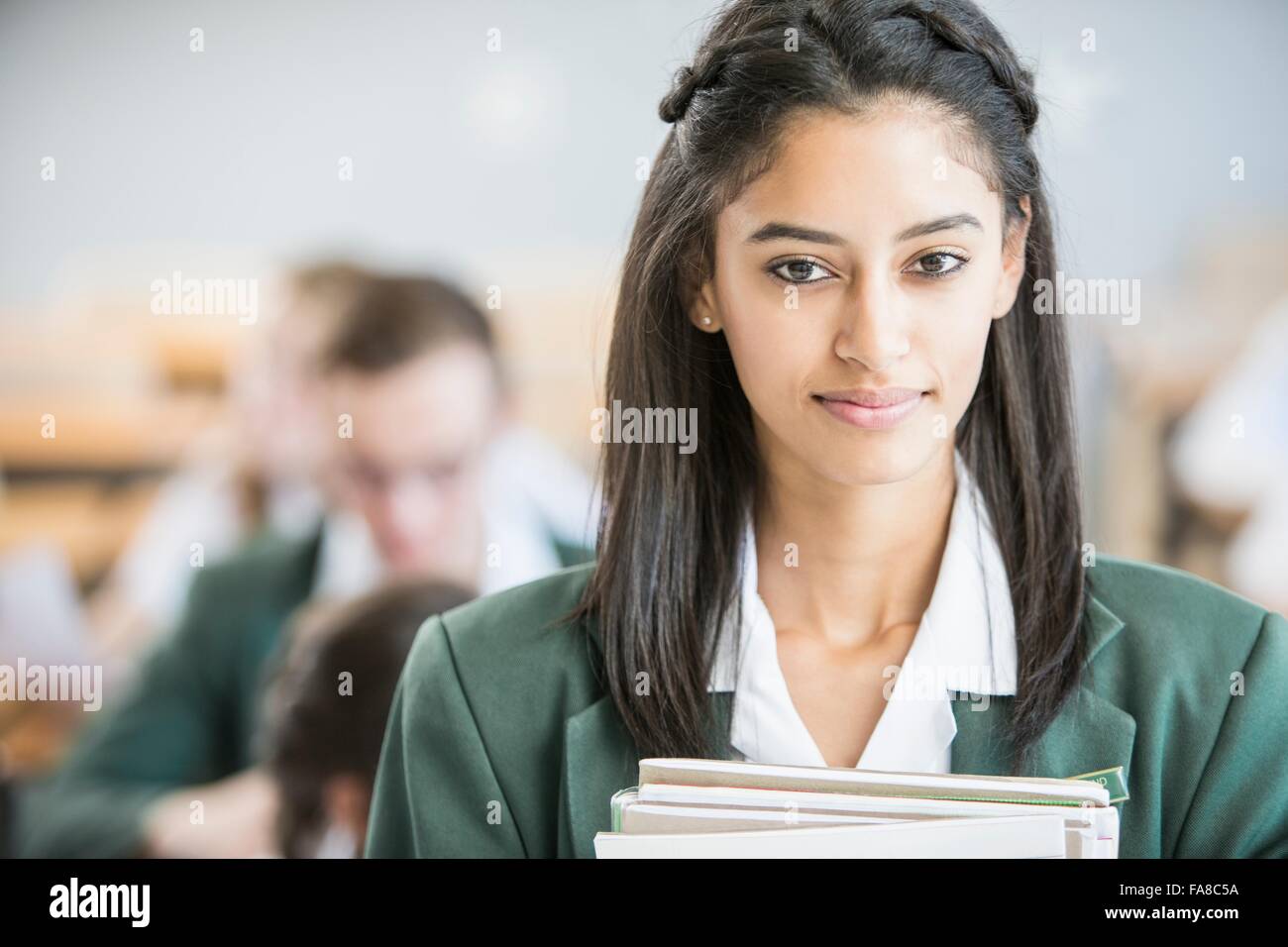 Student in classroom, classmates in background Stock Photo - Alamy