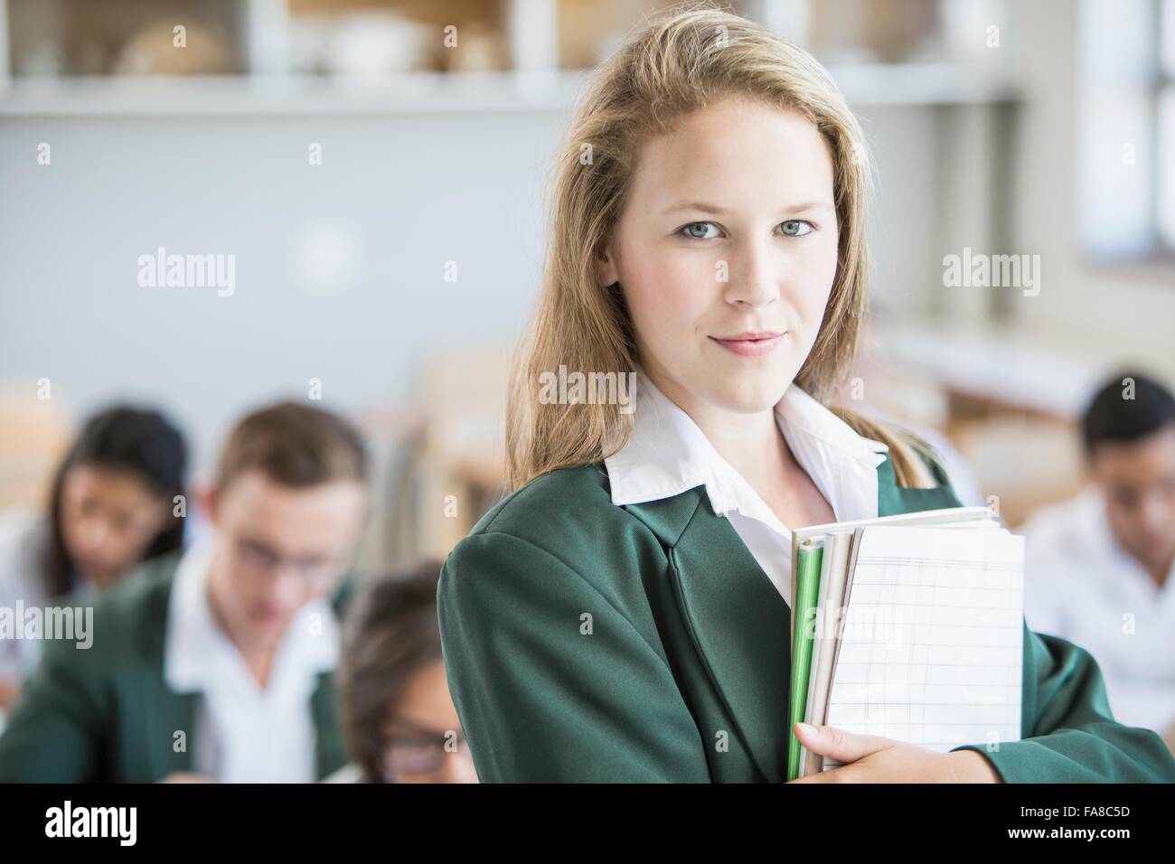 Student in classroom, classmates in background Stock Photo - Alamy