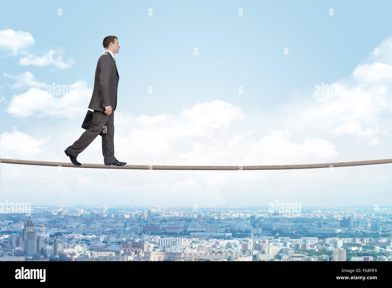 Businessman walking on rope Stock Photo - Alamy