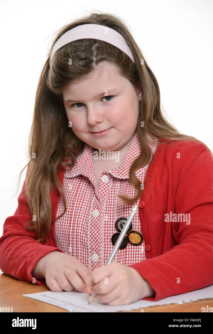 A school girl (Primary School age) studying, reading and writing and ...