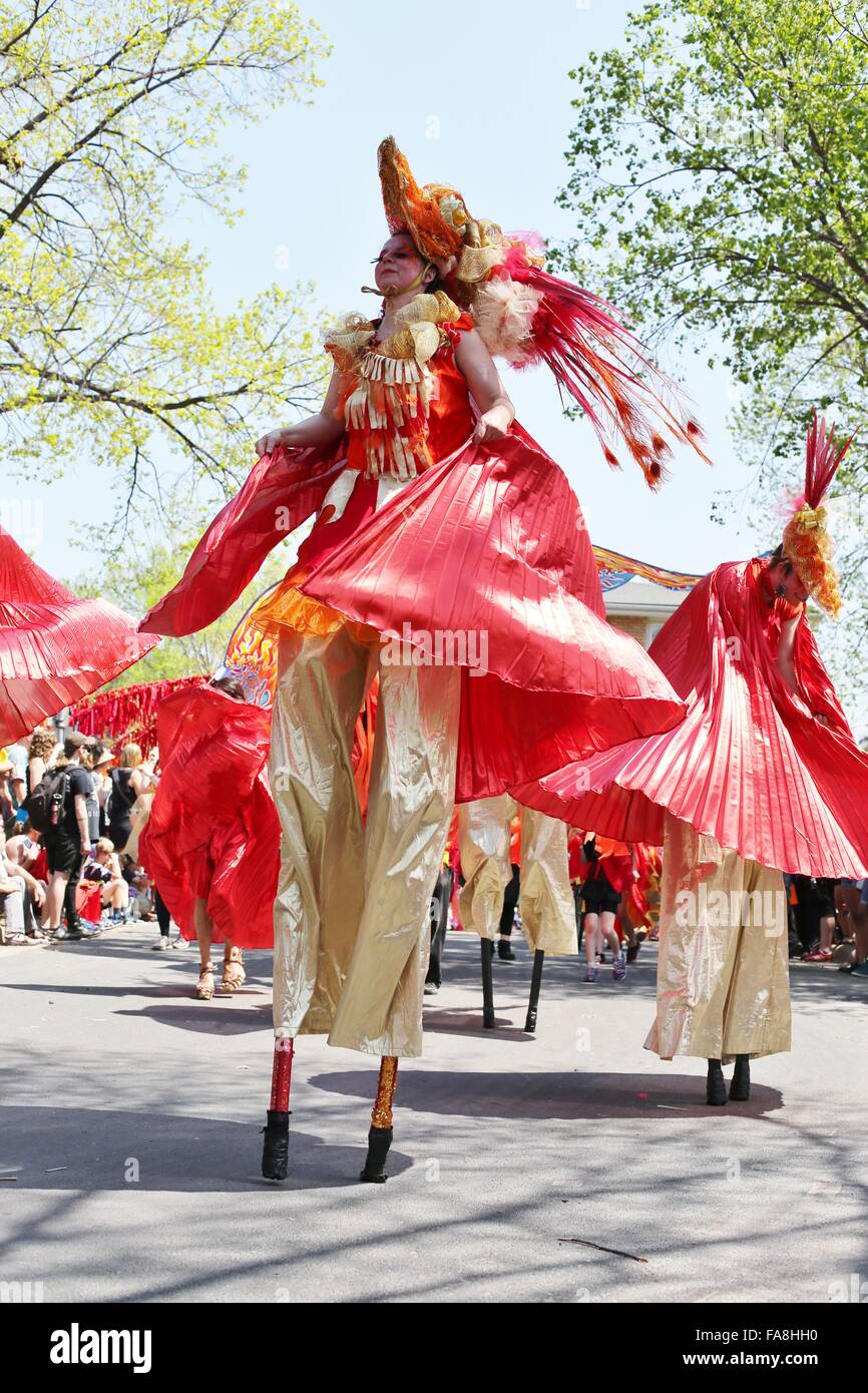 People in colorful costumes and on tall stilts at the May Day parade in ...