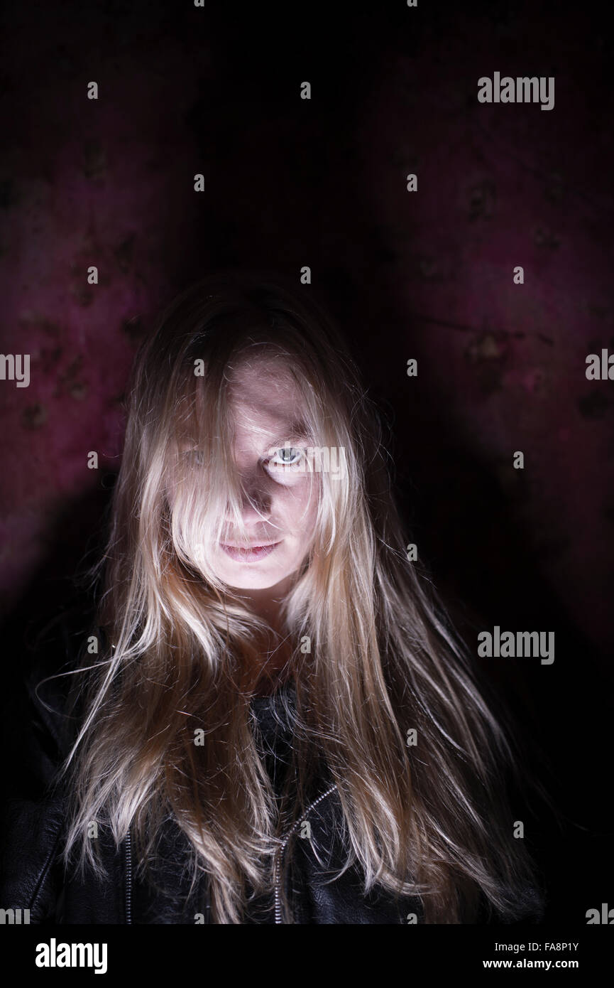 A young slim blonde haired wild eyed crazed deranged woman girl with an ...