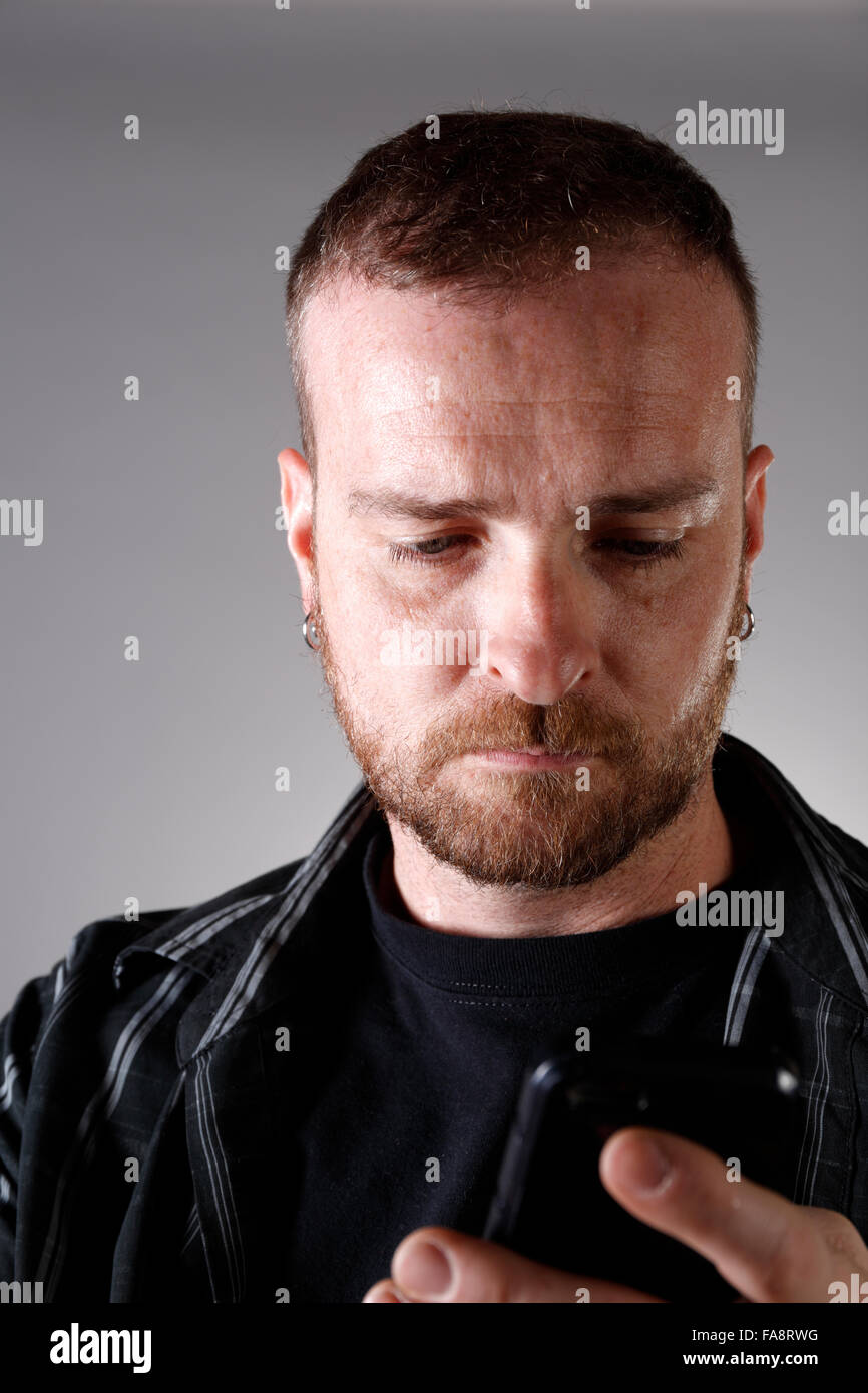 Man looking down at phone Stock Photo - Alamy