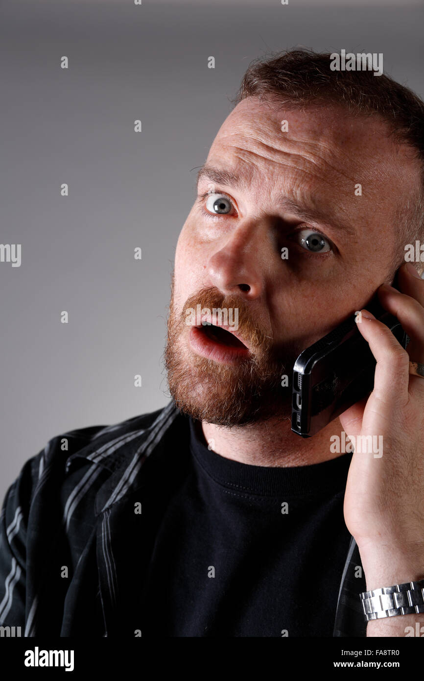 Man surprised on phone Stock Photo - Alamy