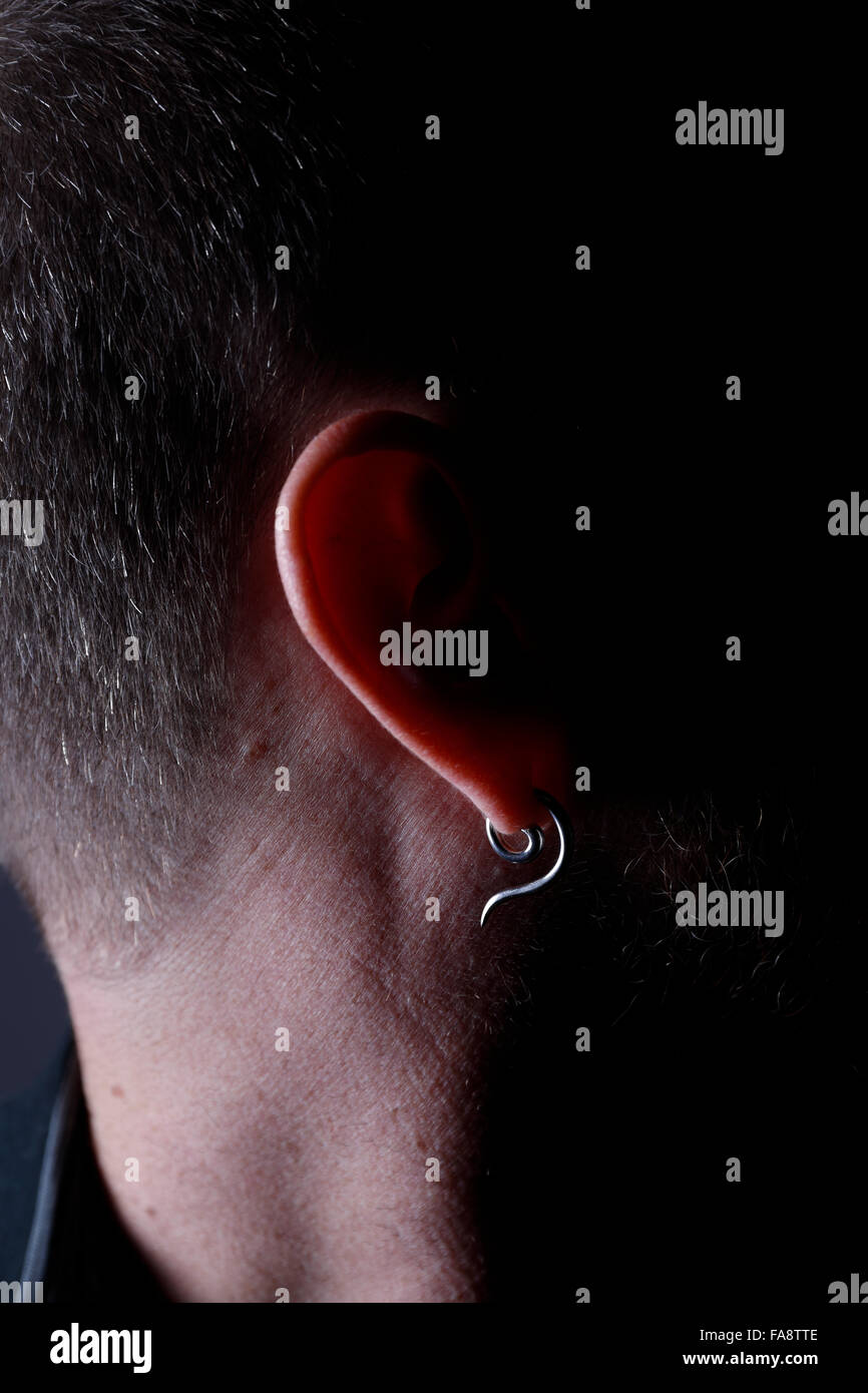 Male ear with spiral earring Stock Photo - Alamy