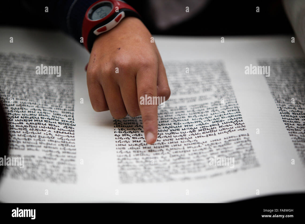A young Jewish boy reads from the Torah as he celebrates his Bar ...