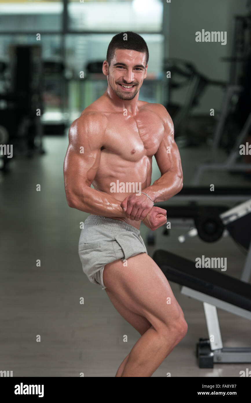 Awesome Bodybuilder Showing His Muscles And Posing In Gym Stock Photo ...