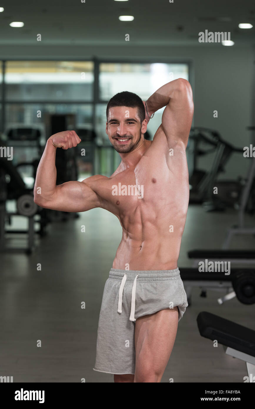 Awesome Bodybuilder Showing His Muscles And Posing In Gym Stock Photo ...