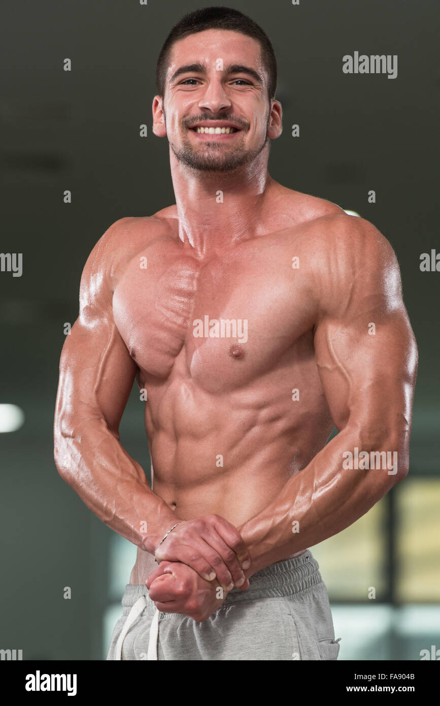 Awesome Bodybuilder Showing His Muscles And Posing In Gym Stock Photo ...