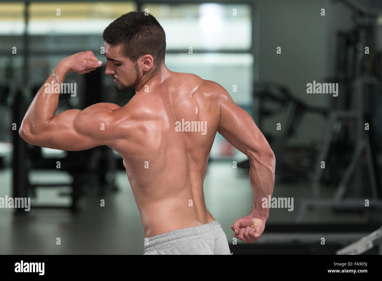 Awesome Bodybuilder Showing His Muscles And Posing In Gym Stock Photo ...