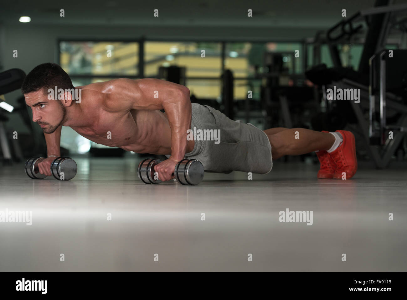 Young Athlete Doing Pushups With Dumbbells As Part Of Bodybuilding ...