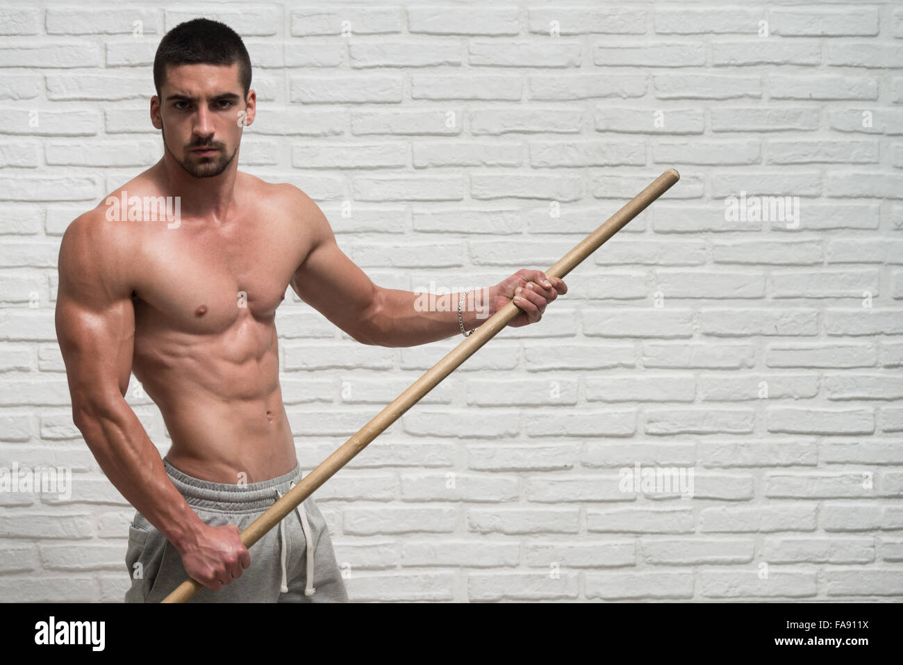 Athlete Muscular Bodybuilder Emotional Posing At The Wall With Stick ...