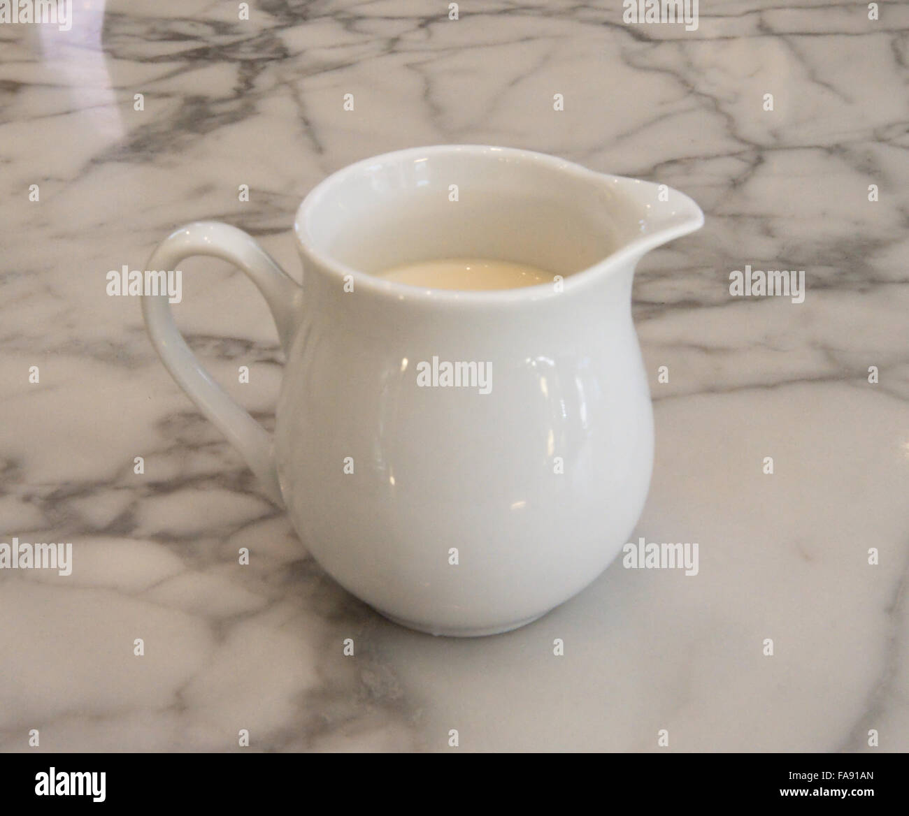 Pitcher of milk on marble table Stock Photo - Alamy