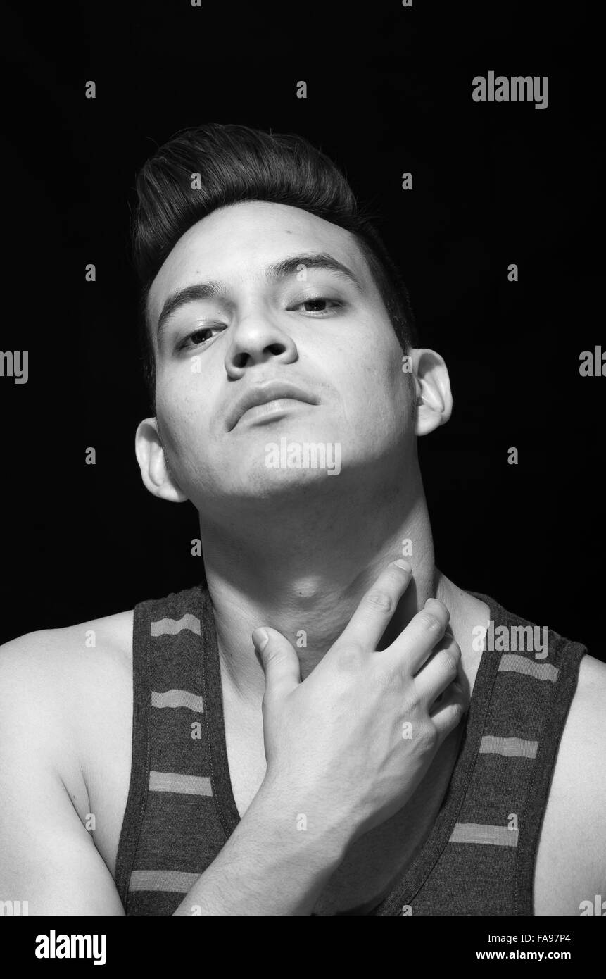 Hispanic male wearing striped singlet touching his own shoulder neck ...