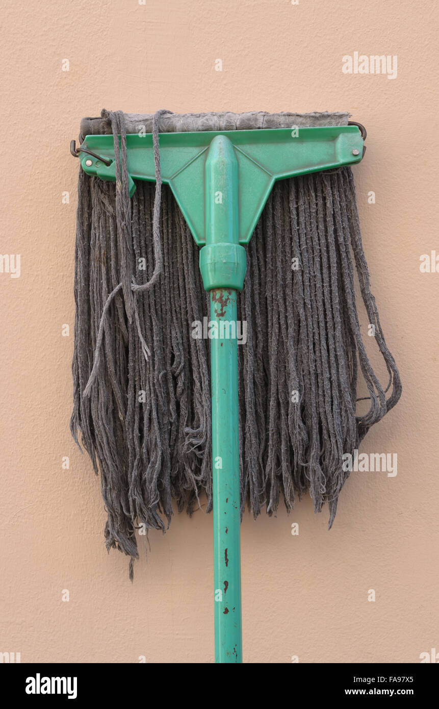 Old mop lying against a pink wall Stock Photo - Alamy