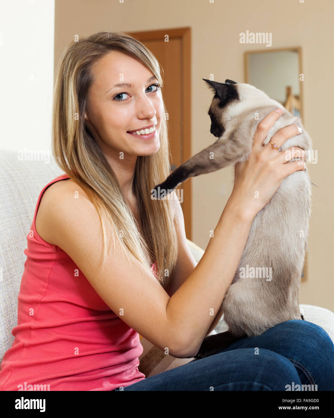Happy girl holding Siamese kitten in arms and smiling Stock Photo - Alamy