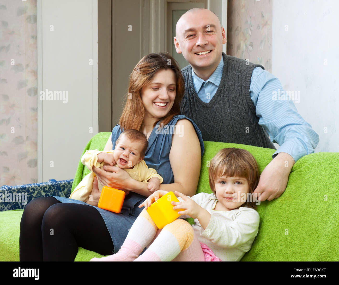 Happy family with two children enjoying time in living room at their ...