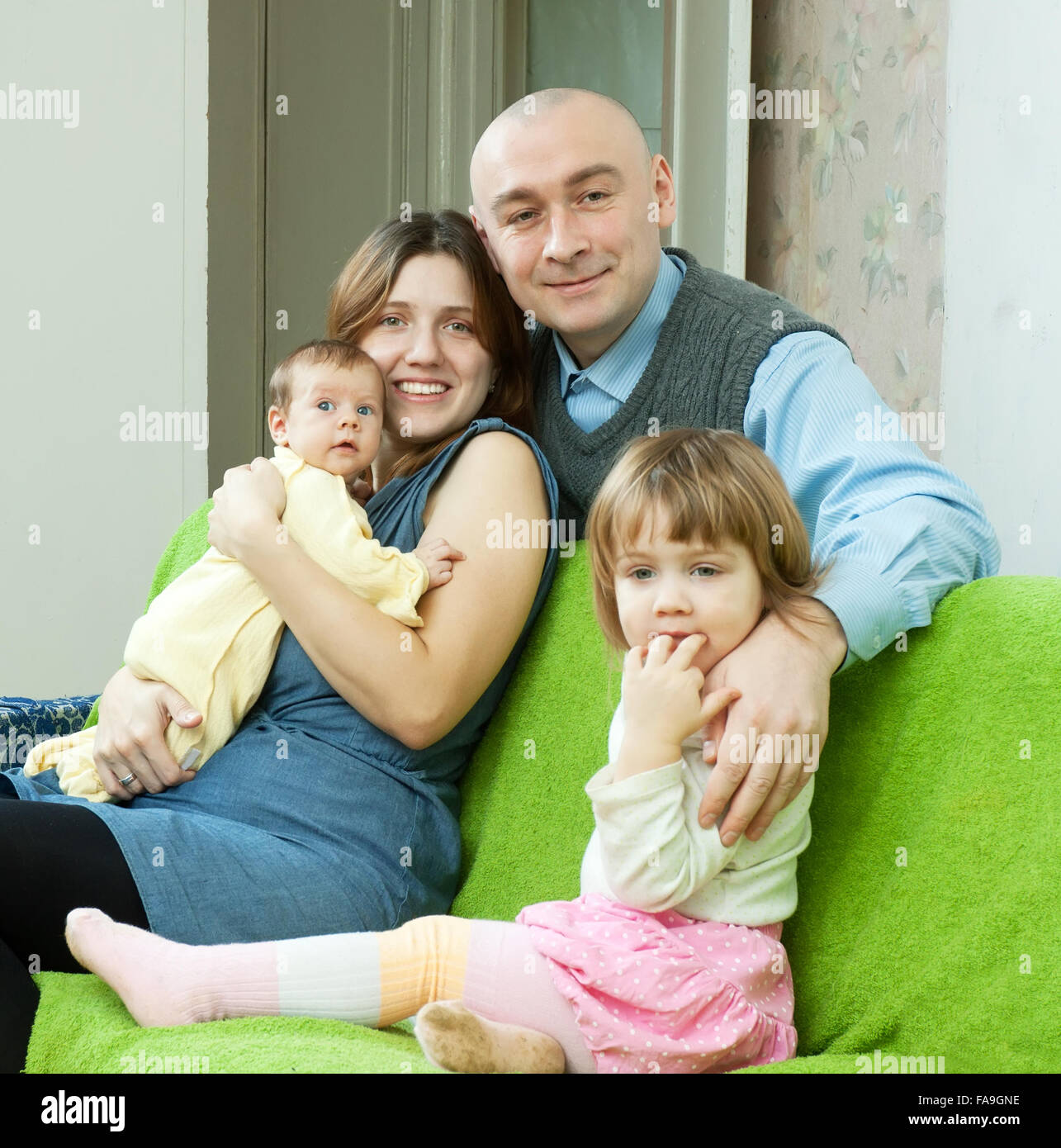 Smiling parents with two kids at home interior Stock Photo - Alamy