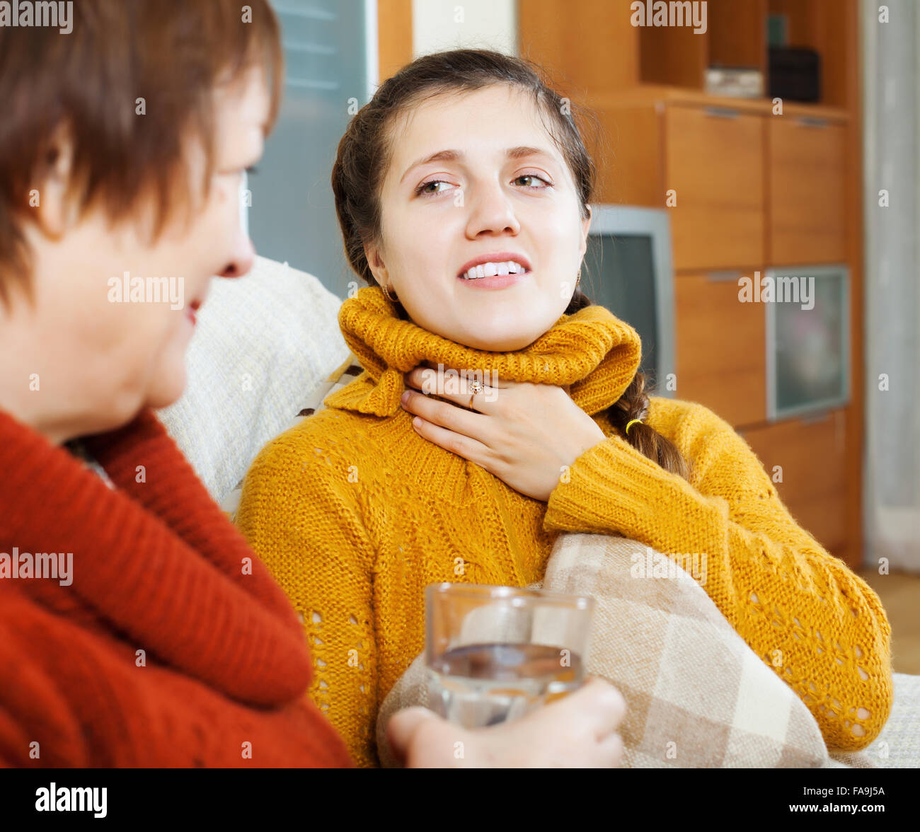 Mature woman caring for sick adult daughter has cold at home Stock ...