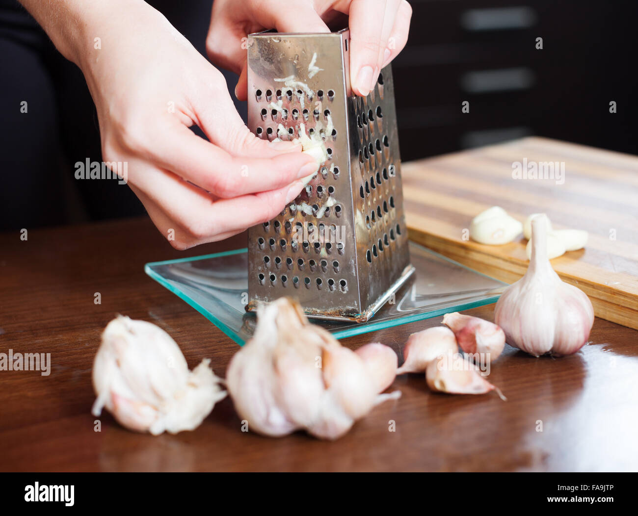 Closeup of hands grating garlic with grater Stock Photo - Alamy