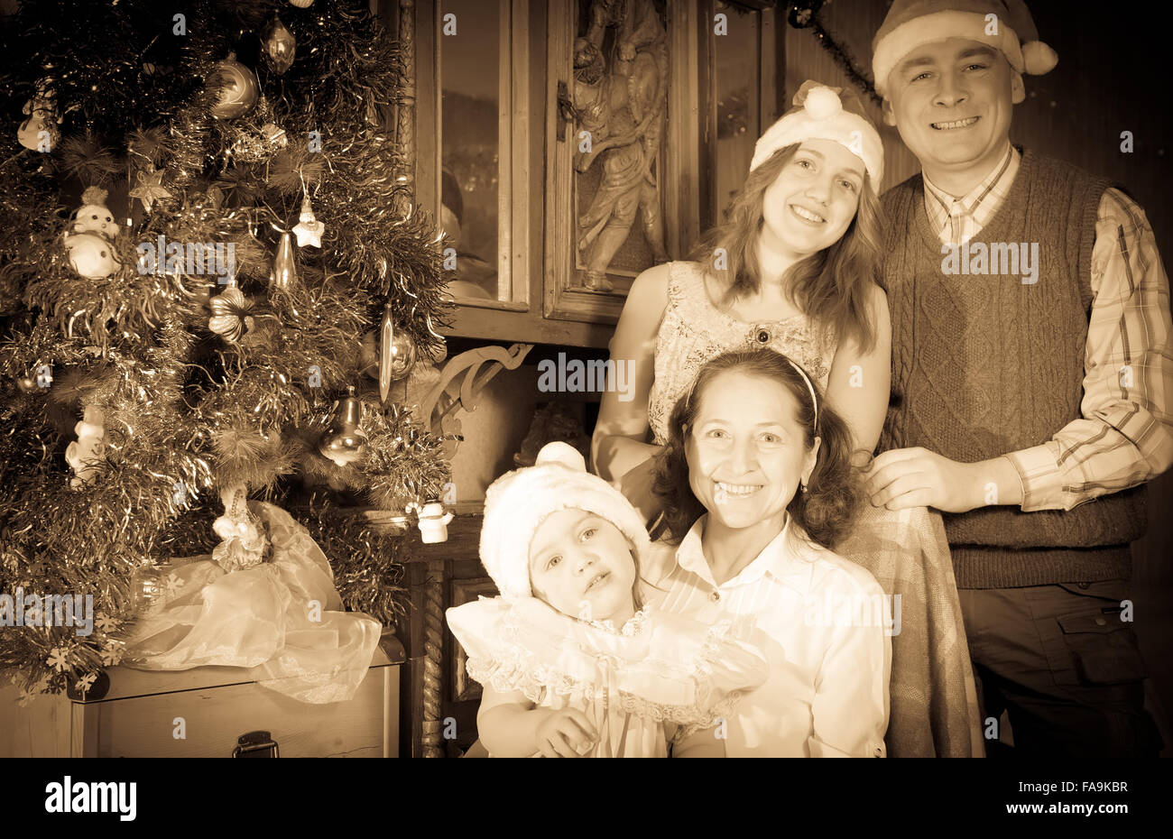 Vintage image of happy family of three generations with Christmas tree ...
