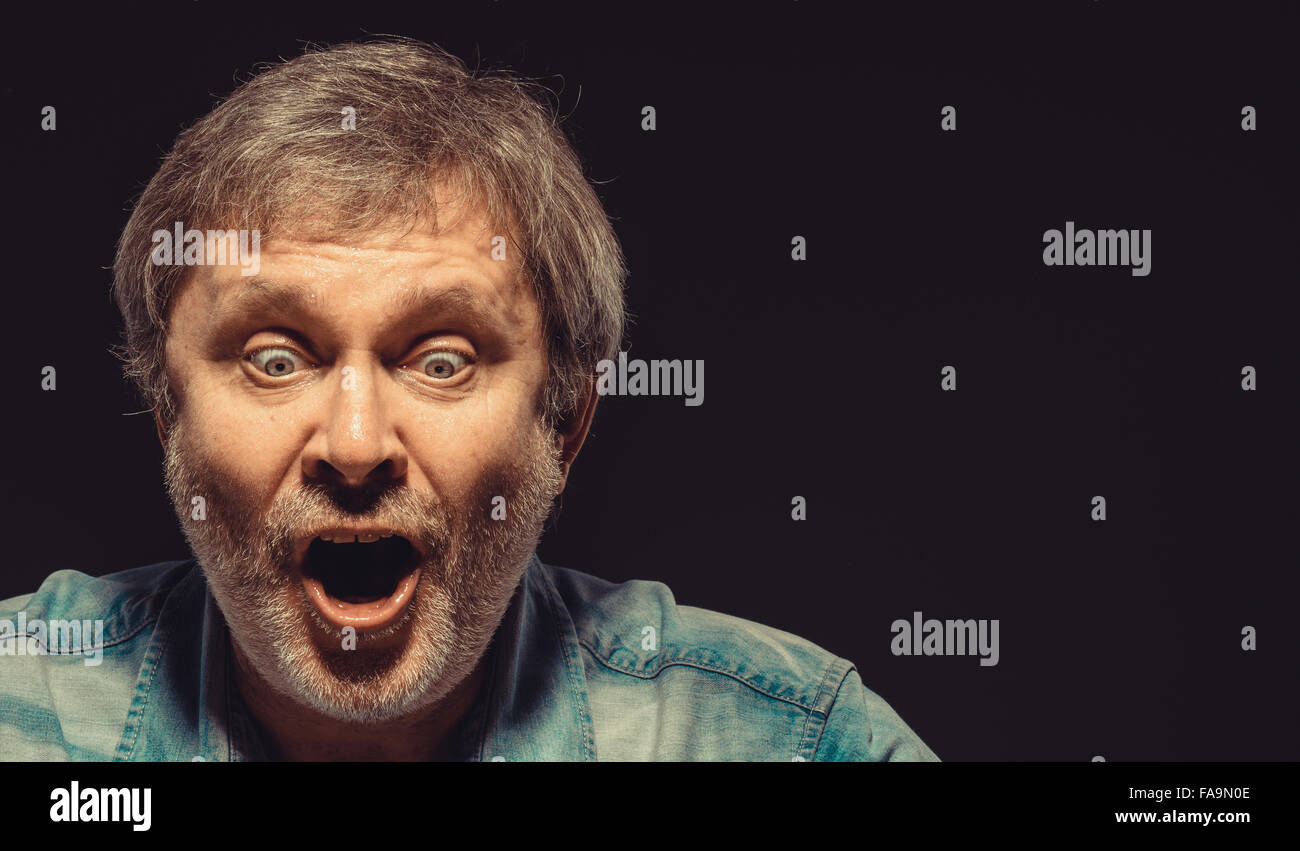 The front view of handsome screaming man as fan in denim shirt ...