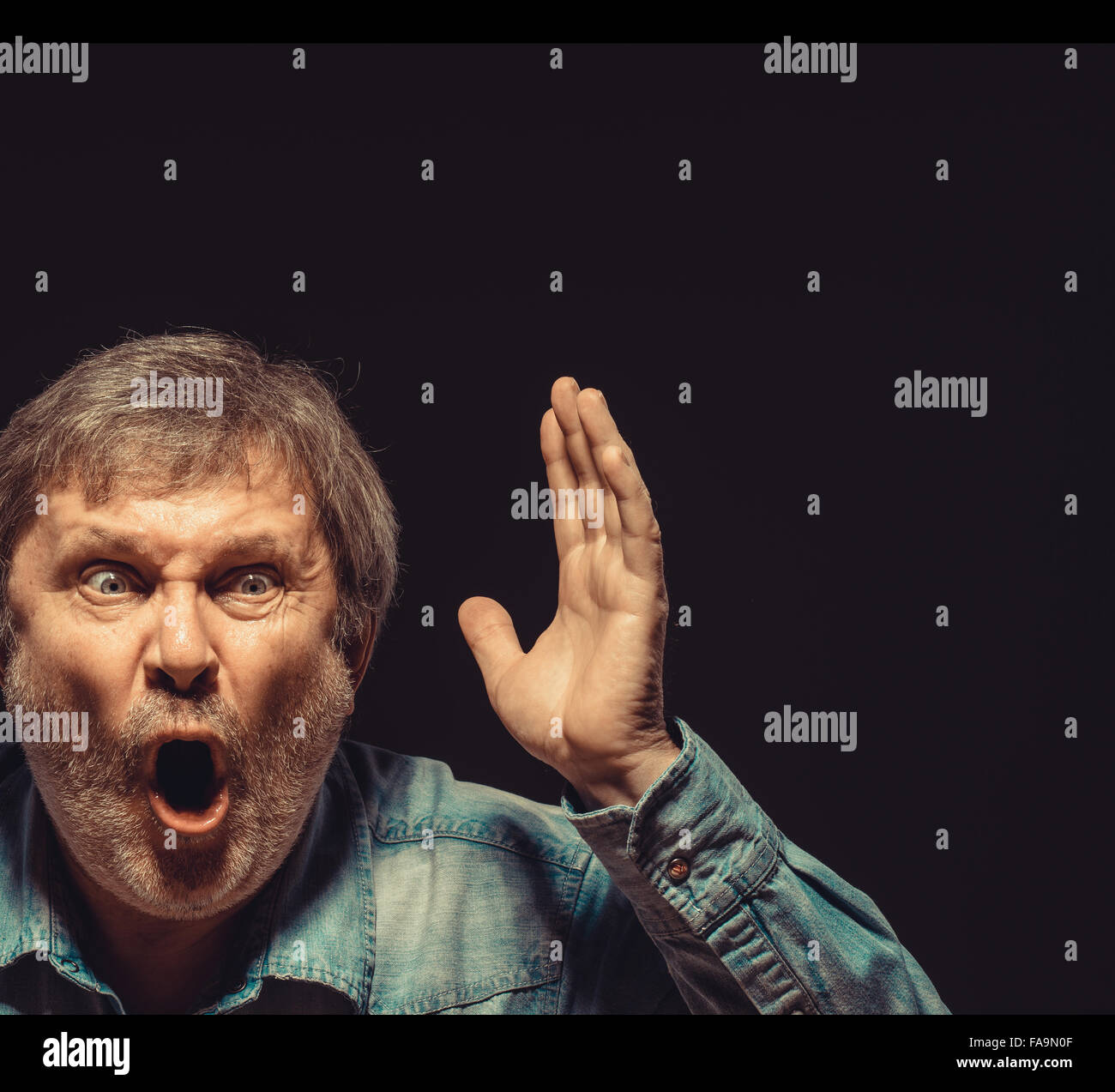 The front view of handsome screaming man as fan in denim shirt ...