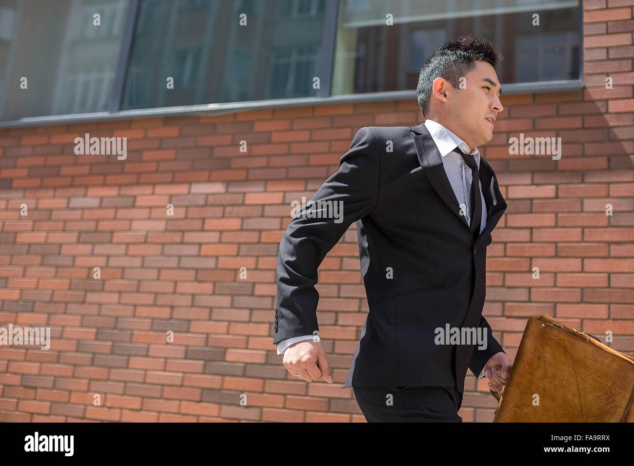 Chinese young businessman running in a city street Stock Photo - Alamy