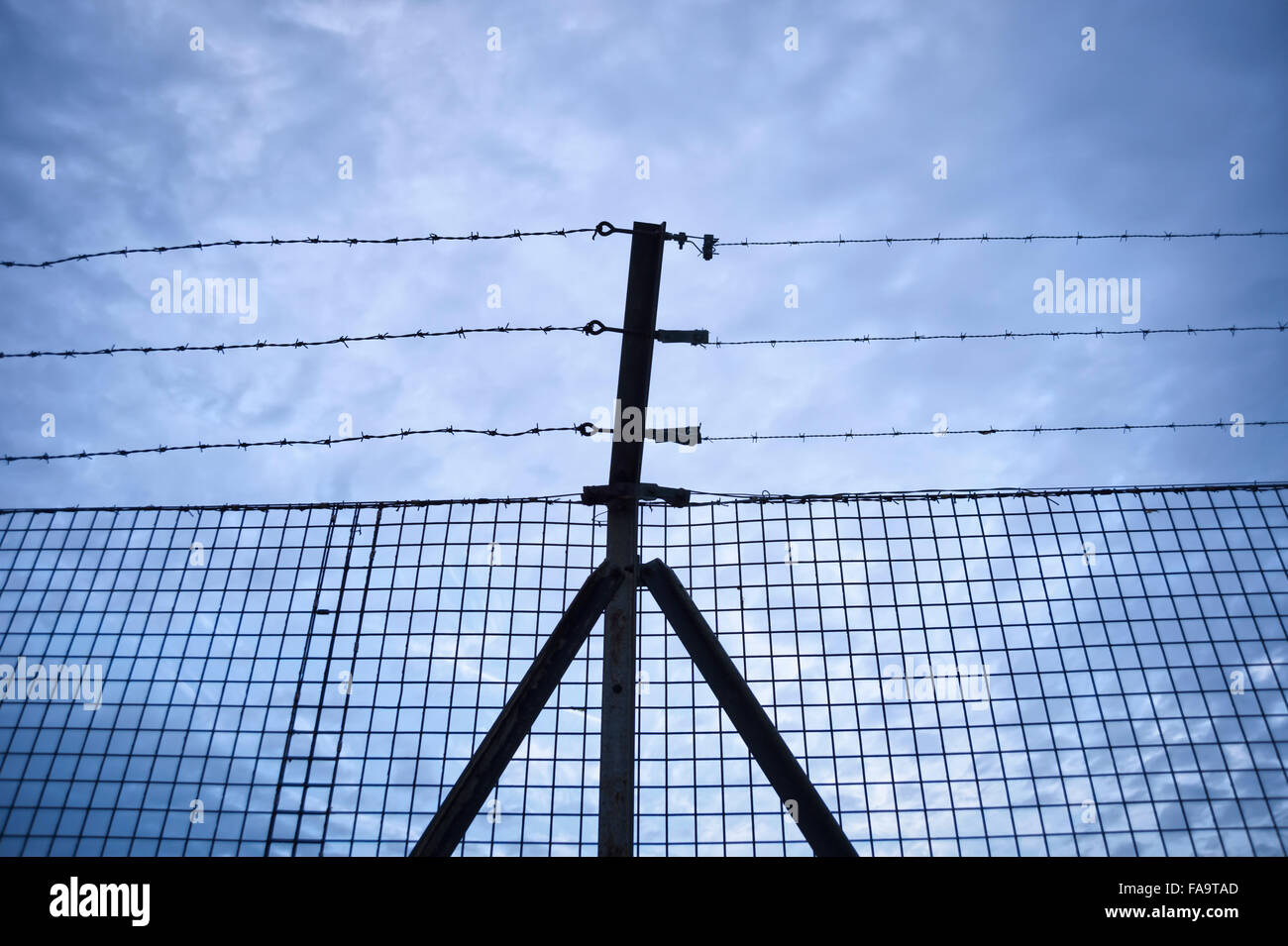 Barbed wire border fence Stock Photo - Alamy