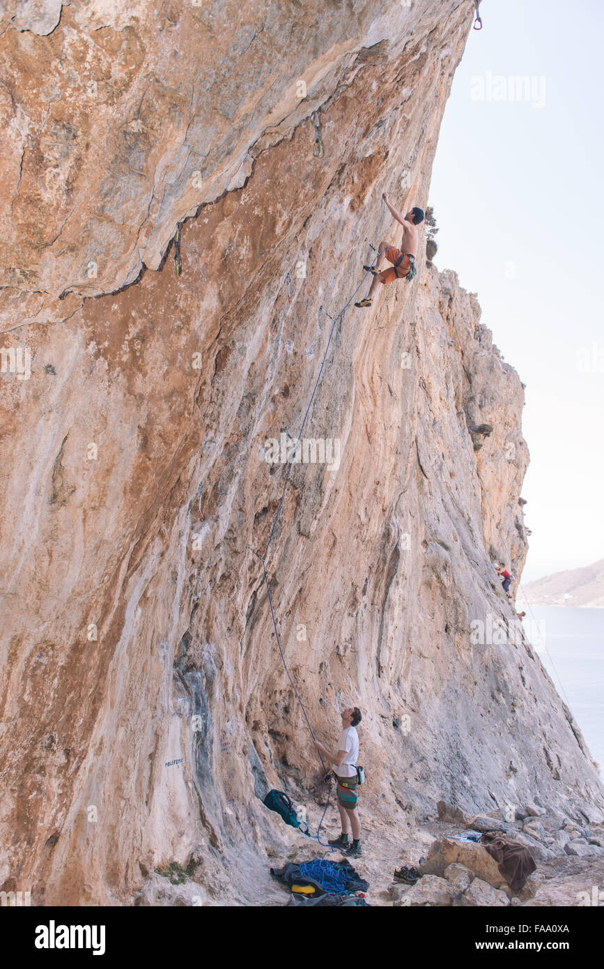 man rockclimbing on steep cliff in greece belayed by partner Stock ...