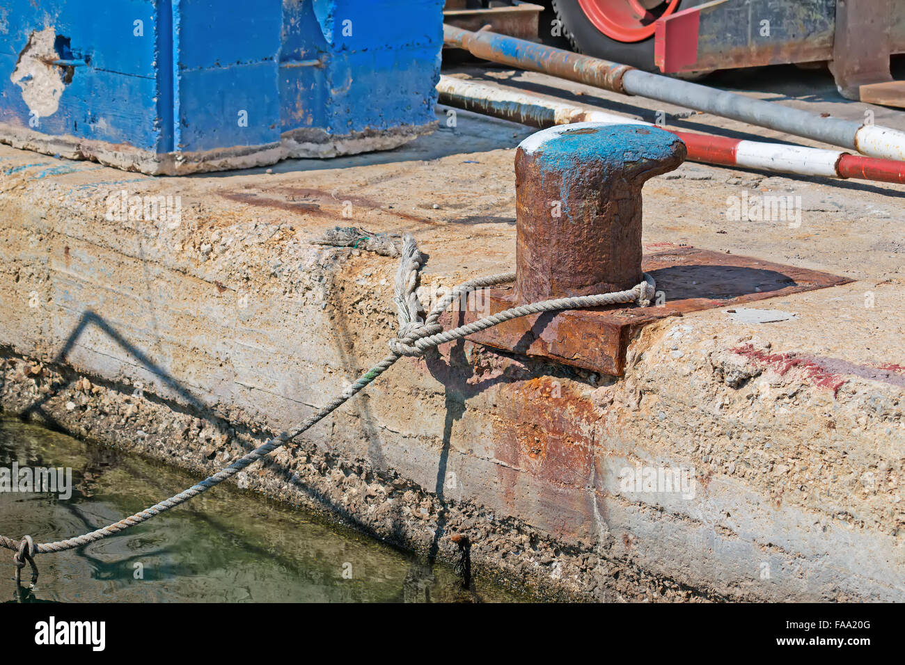 rusty bollard with rope by the shore Stock Photo - Alamy