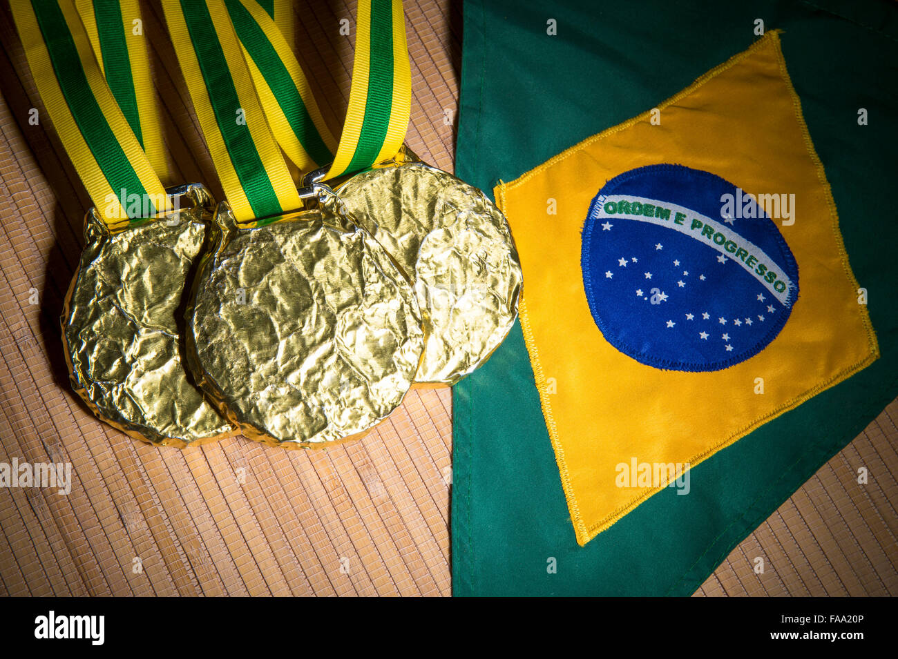 Three gold medals resting on tropical wood background with pennant ...