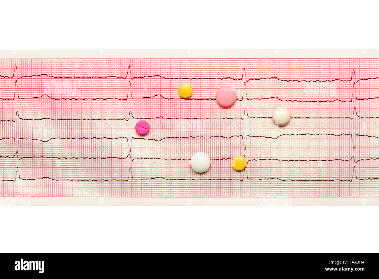 White, yellow and pink tablets on paper ECG results isolated on white ...