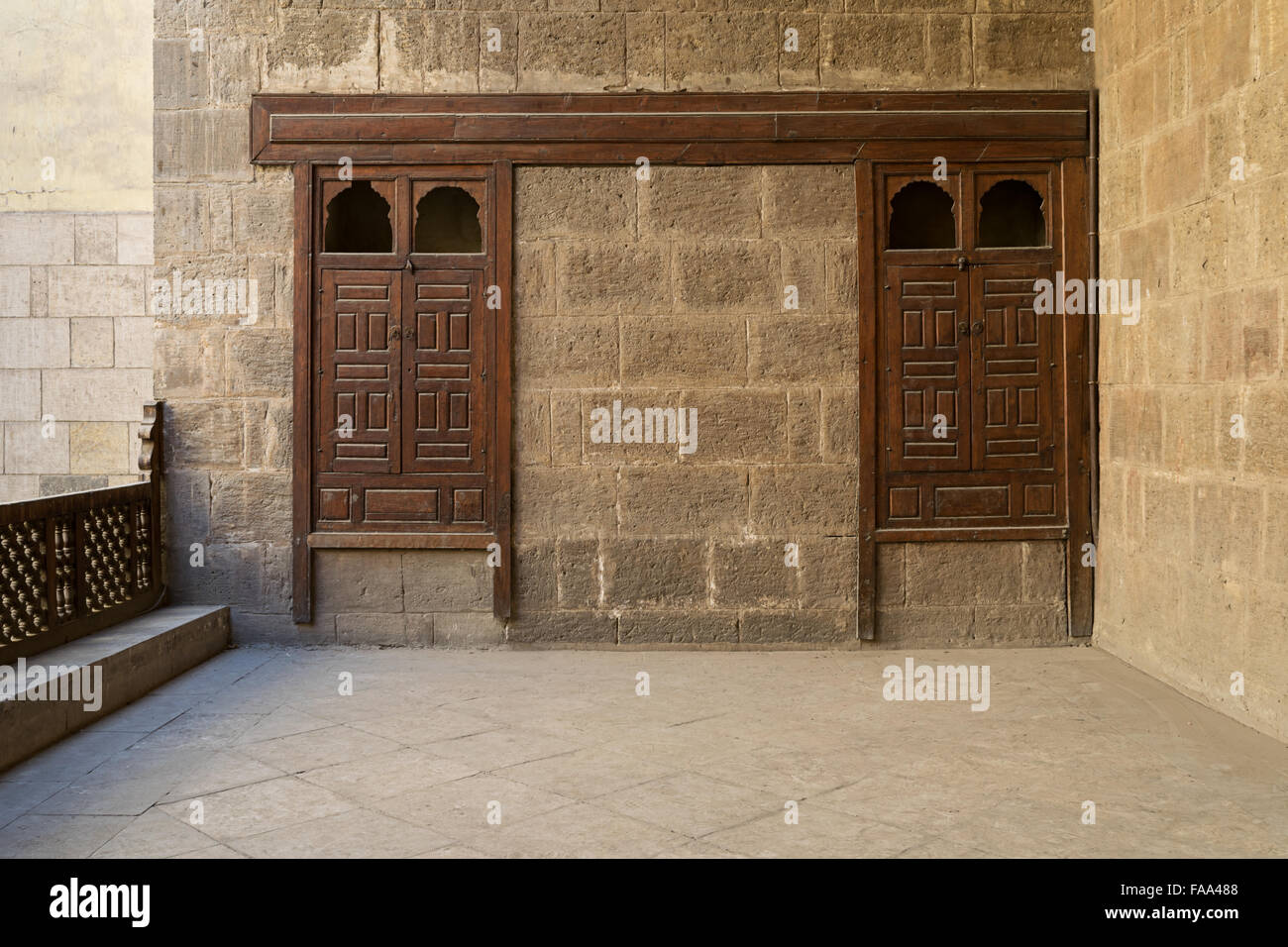 Stone brick wall with two embedded ornamented wooden cupboards at a ...