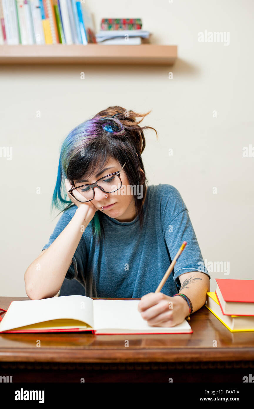 Young meditating teen female student writing on desktop with book Stock ...