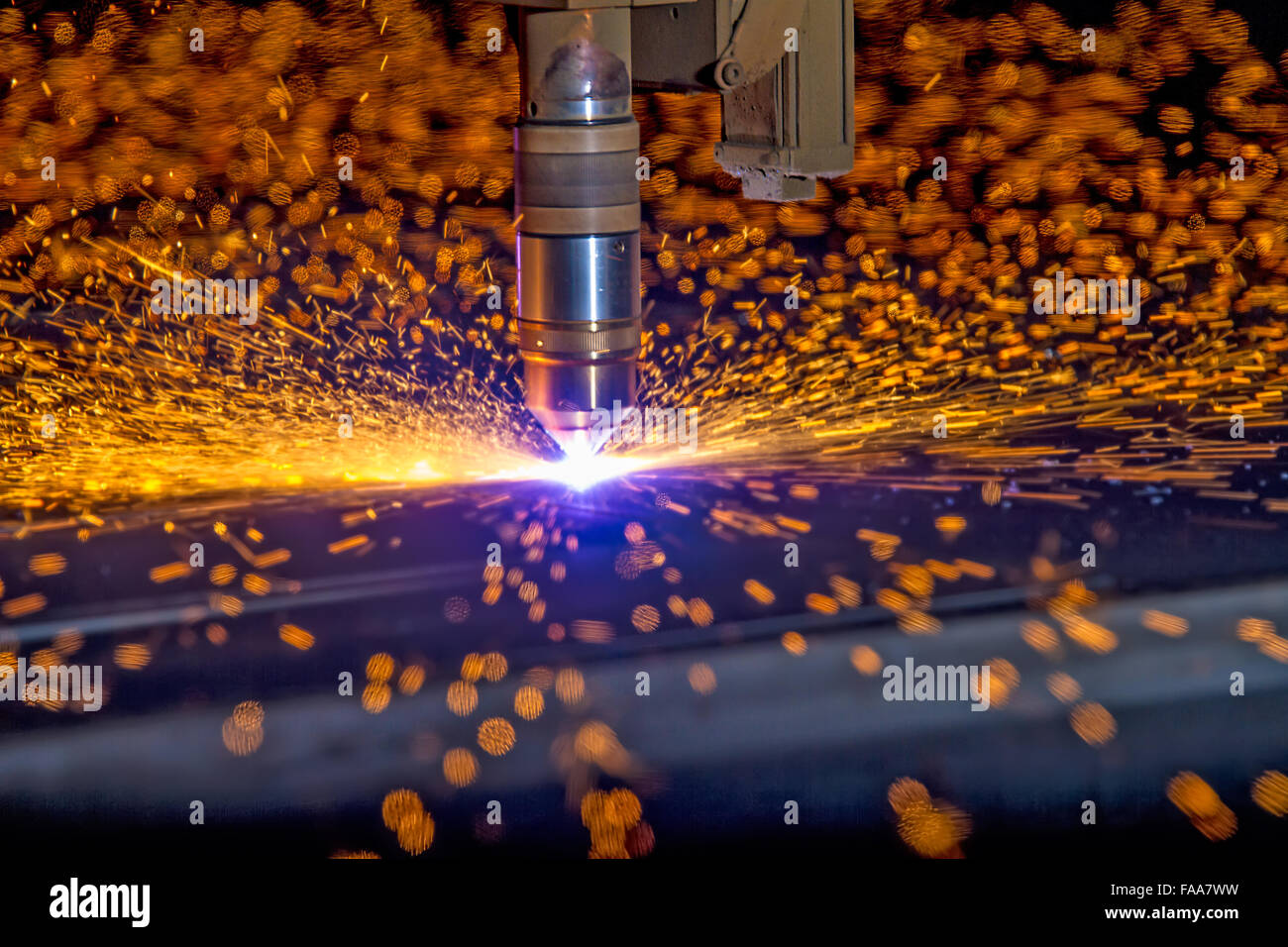 Steel plate being cut by CNC plasma torch with orange bokeh sparks ...