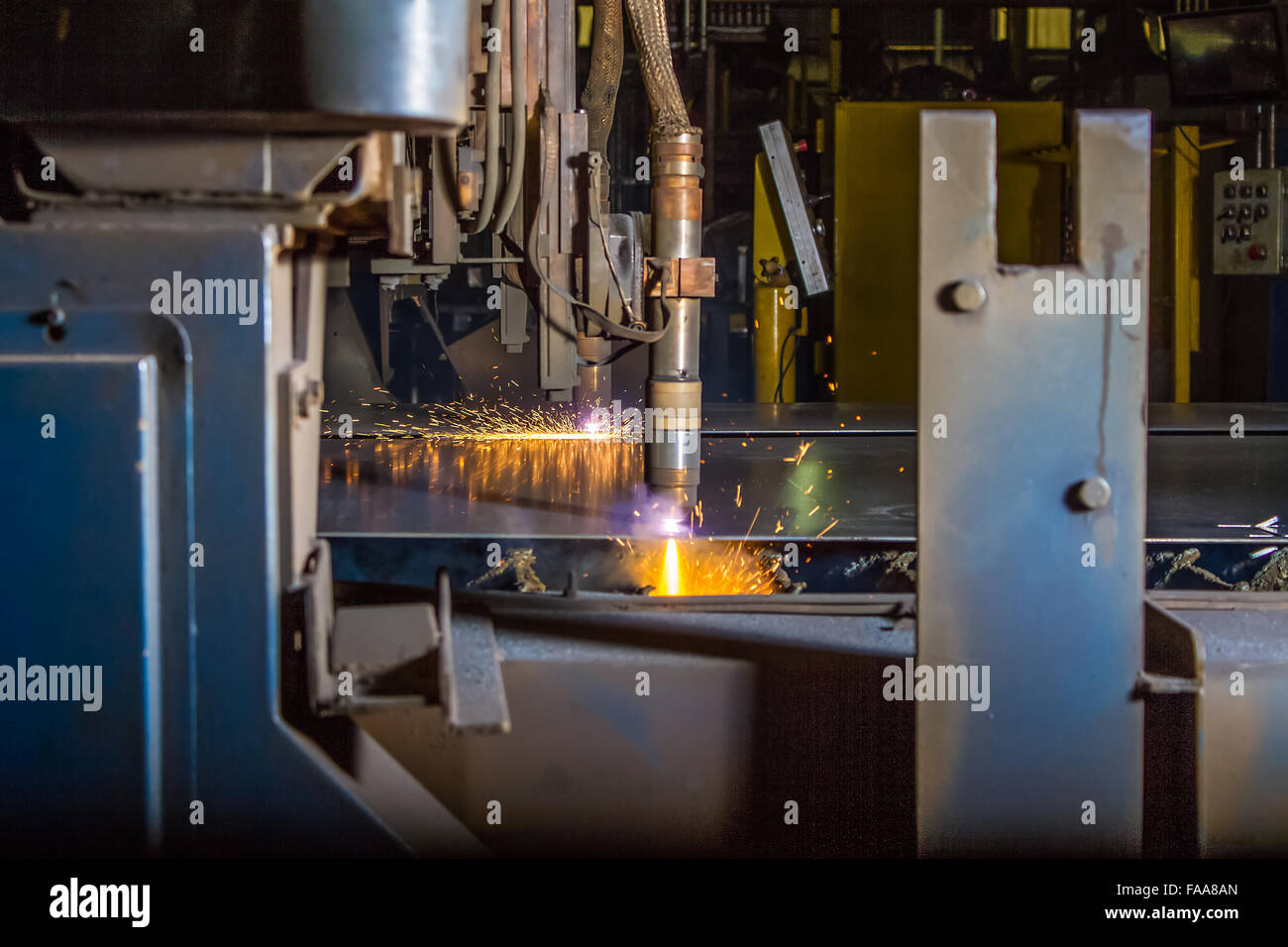 Steel plate being cut by 2 CNC plasma torches with orange sparks ...