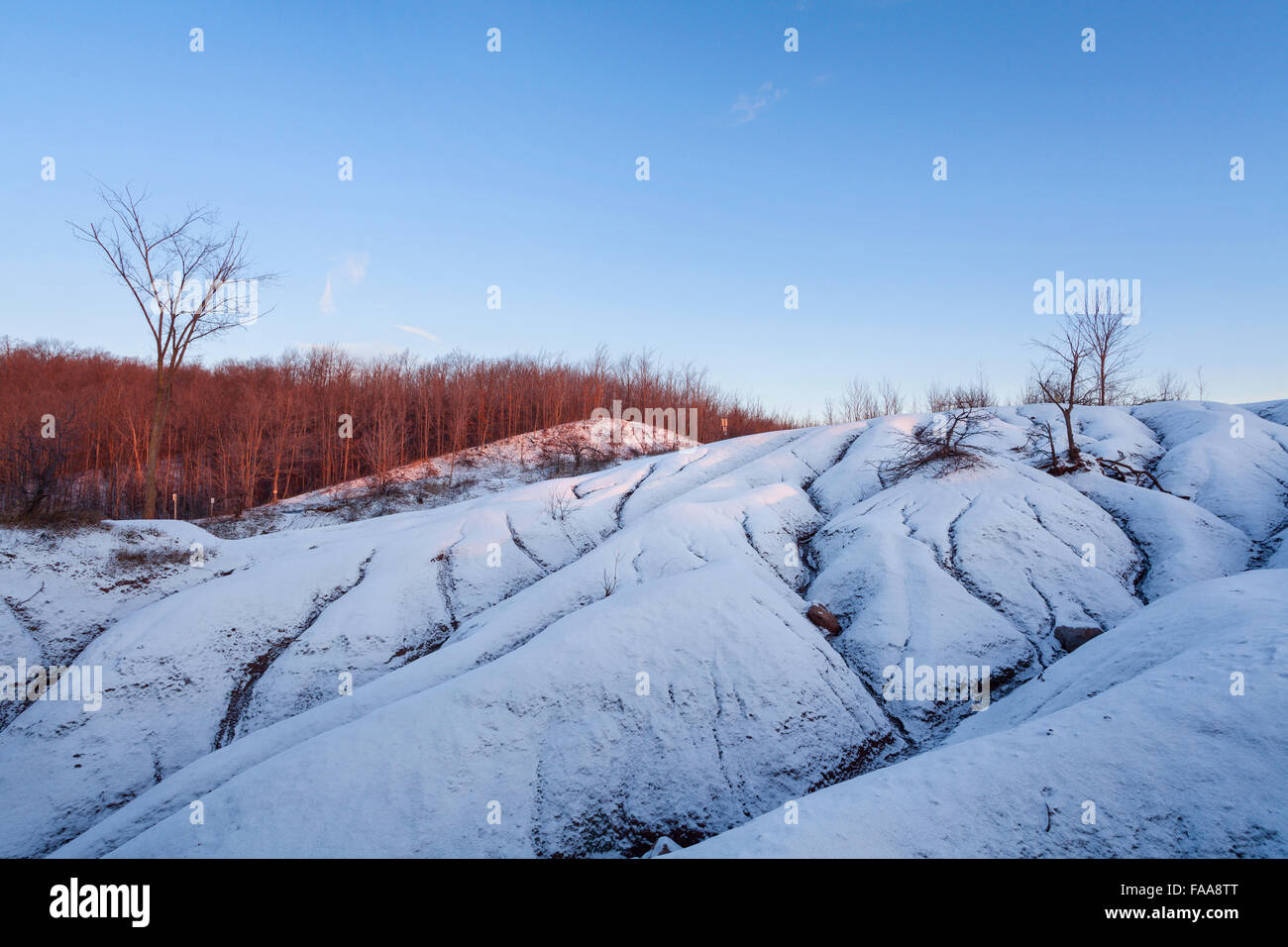 The sun rising on the Cheltenham Badlands covered in fresh snow ...