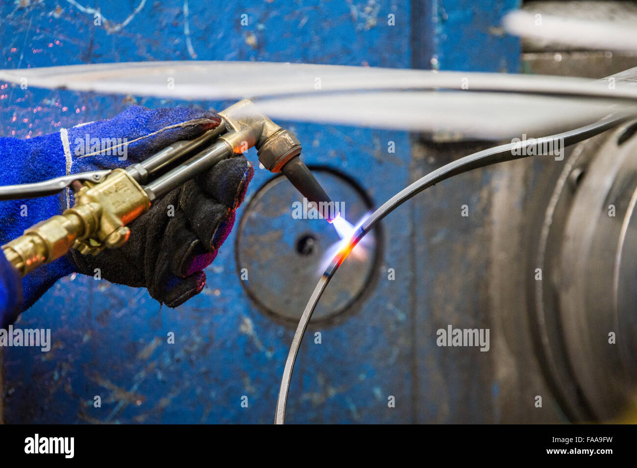 Oxyacetylene welding torch with white flame heating metal strip to red ...