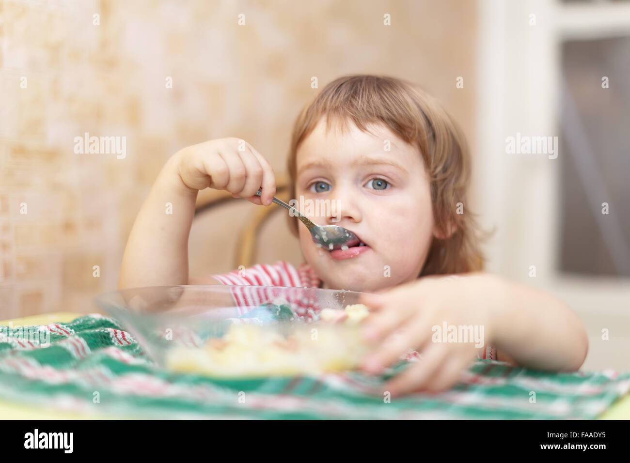 child eats potato with spoon in home Stock Photo - Alamy