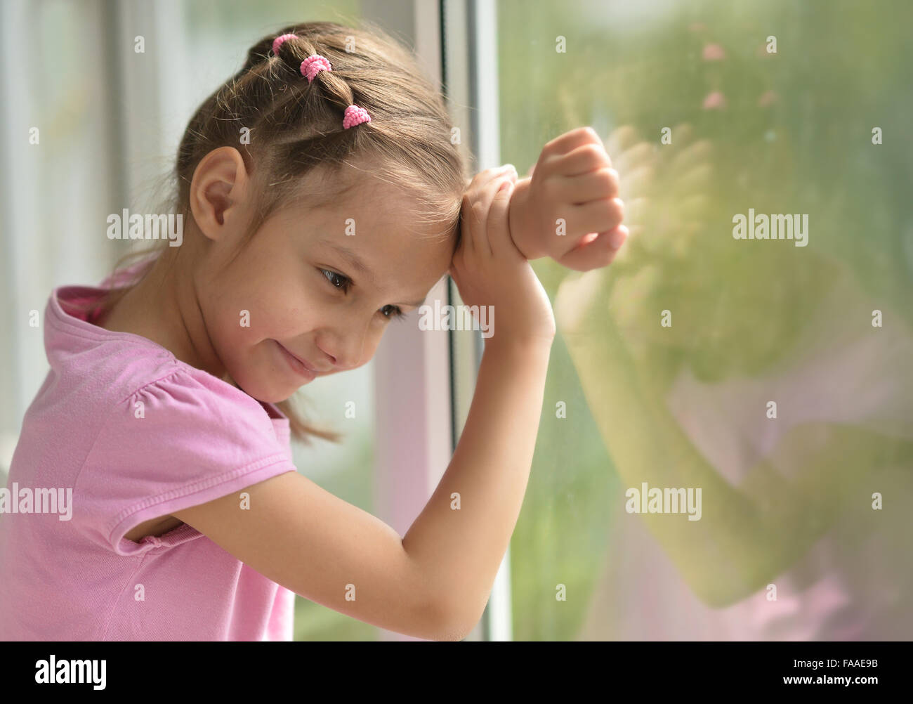 Little girl standing near window Stock Photo - Alamy