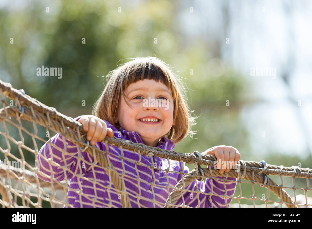 laughing baby girl climbing on ropes Stock Photo - Alamy