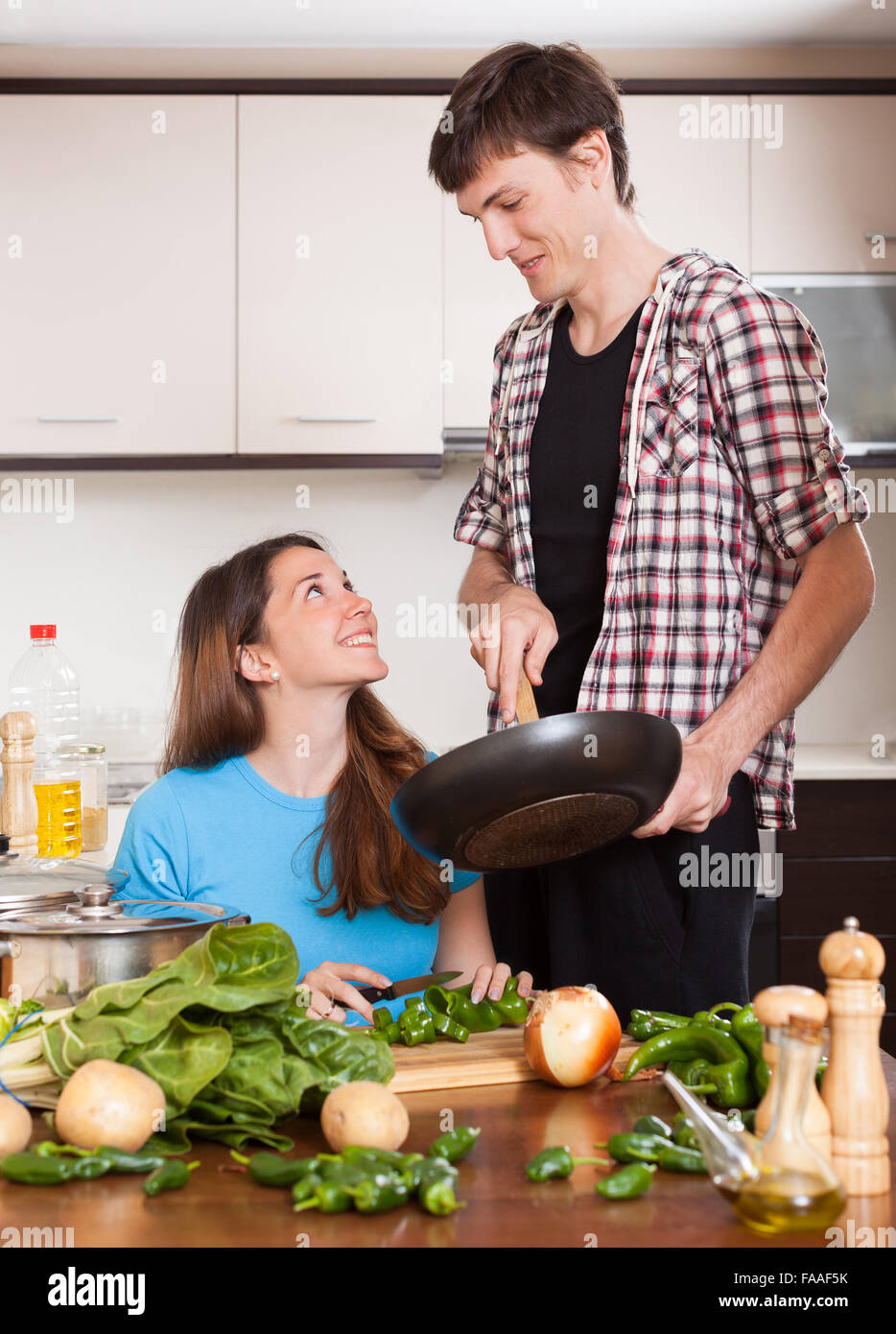 Guy and pretty girl cooking in domestic kitchen Stock Photo - Alamy