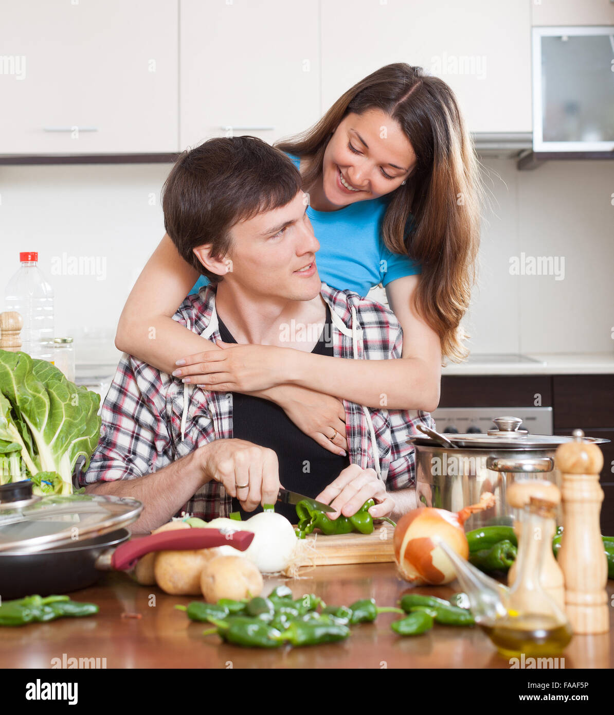 Happy couple cooking in domestic kitchen Stock Photo - Alamy