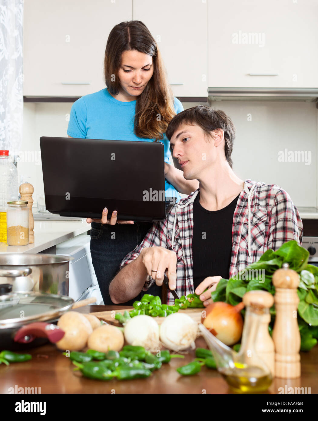 girl shows the new recipe on laptop during dinner cooking Stock Photo ...